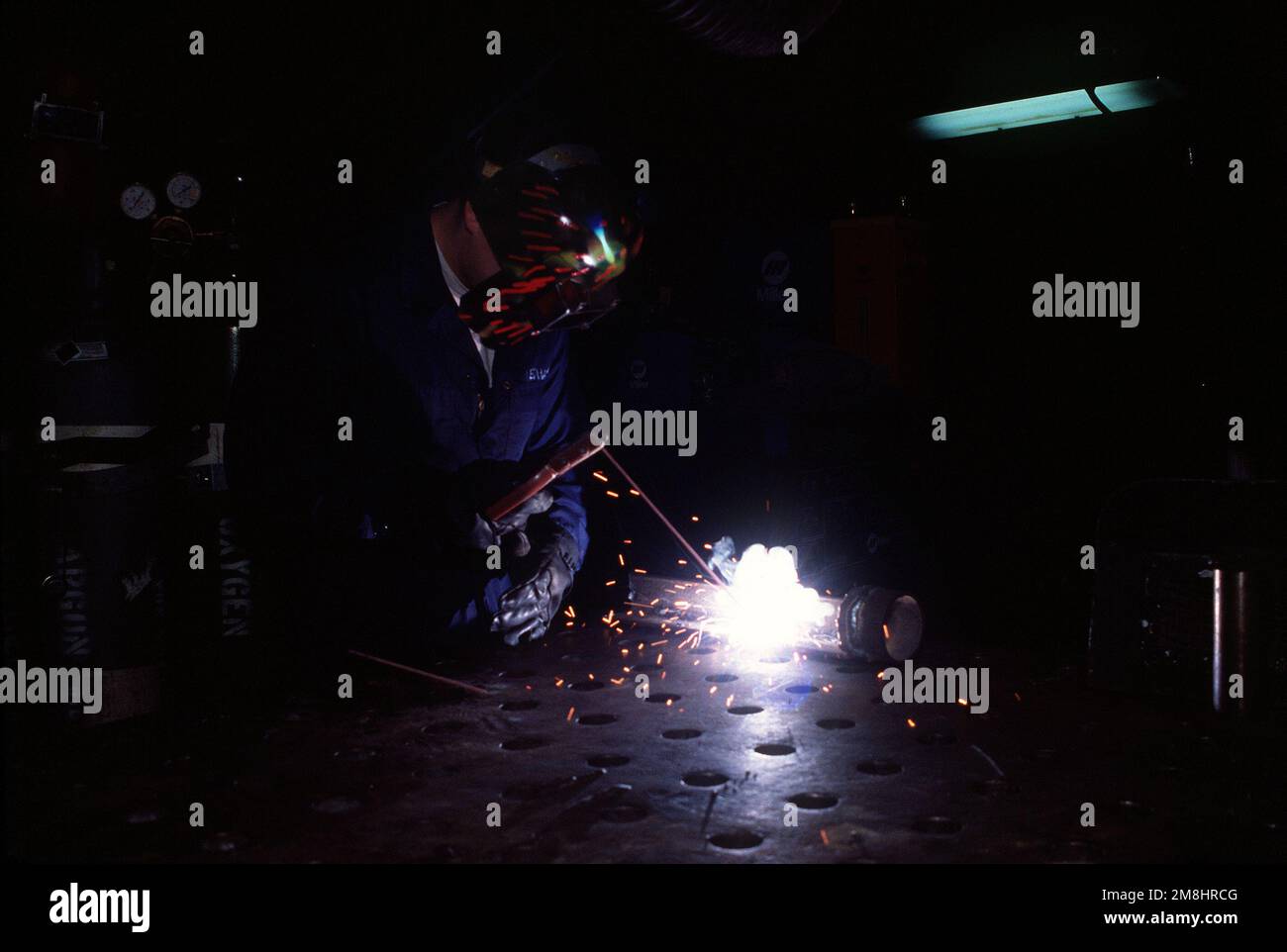 A shipfitter performs a welding task in the welder's shop of the ...