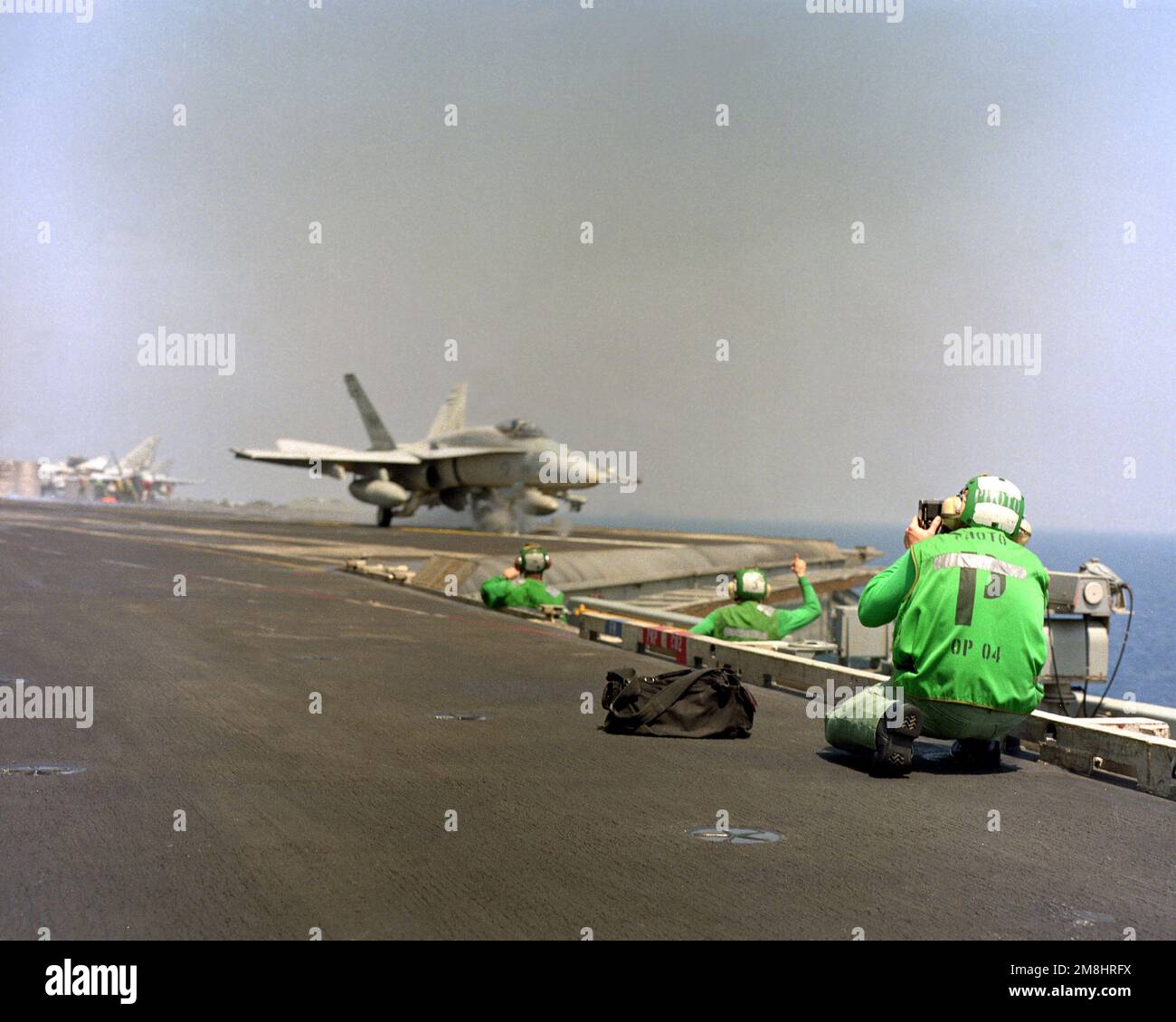 Photographers Mate First Class (PH1) David M. Miller photographs an F/A ...