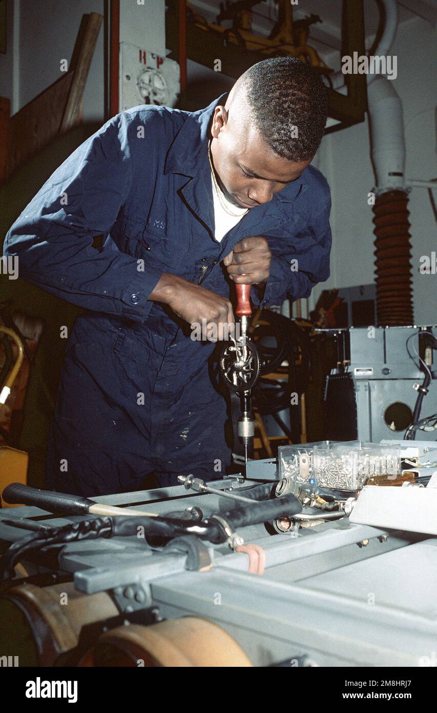 Aviation Mechanic AIRMAN (AMHN) Adrean R. Sims secures a sheet of metal ...