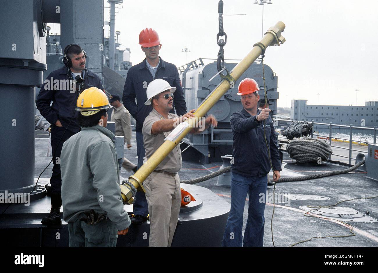 Members of the Weapons Division inspect a lifting bar before using it ...