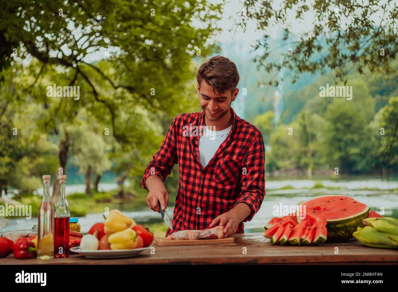 A man preparing a delicious dinner for his friends who are having fun ...