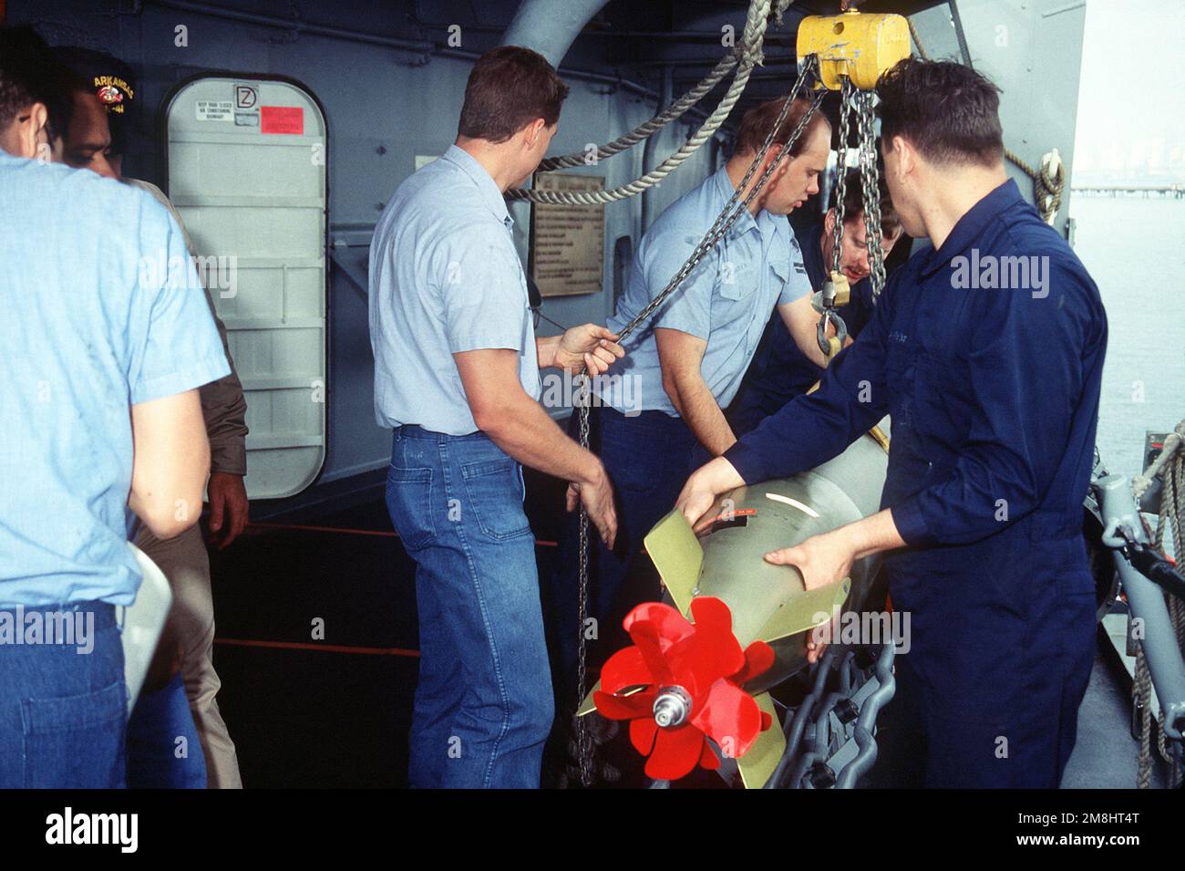 Members of the Weapons Division load a Mark 46 torpedo into one of the ...