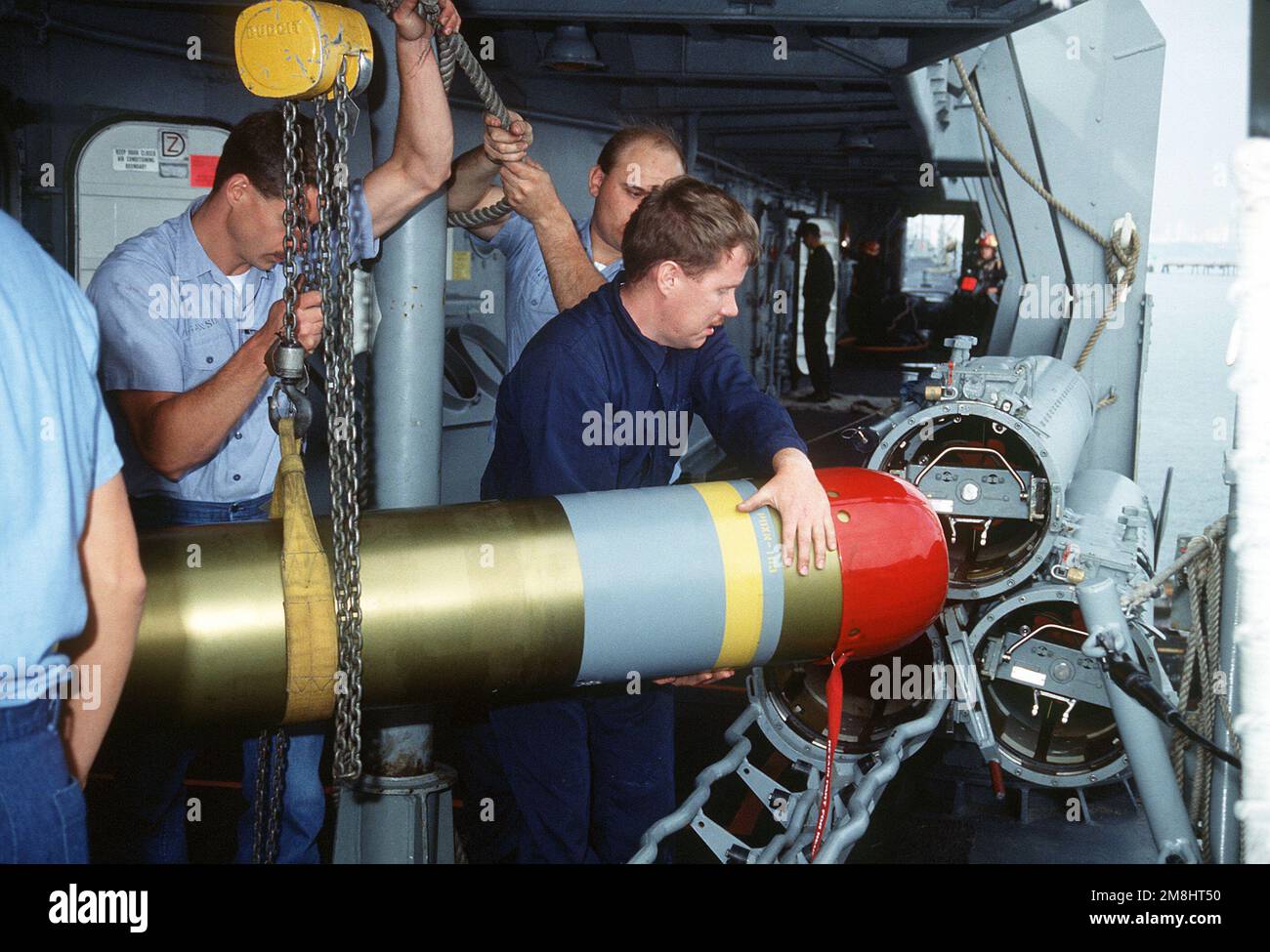 Members of the Weapons Division load a Mark 46 torpedo into one of the ...