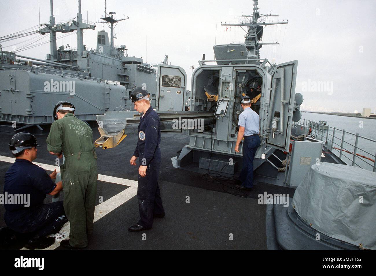Members of the Weapons Division prepare to retract the loading rail ...