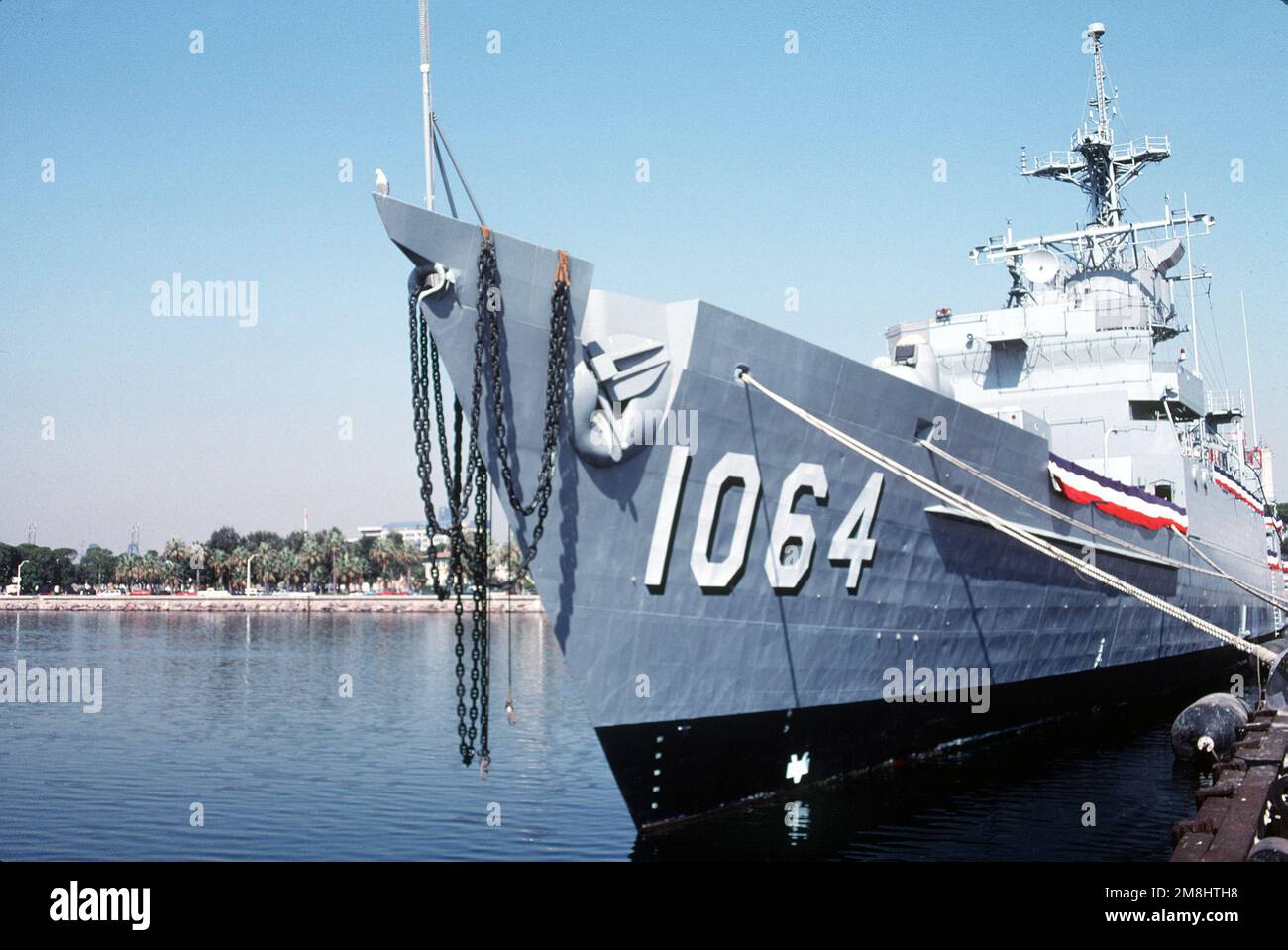 A port bow view of the frigate USS LOCKWOOD (FF-1064) tied to a pier ...