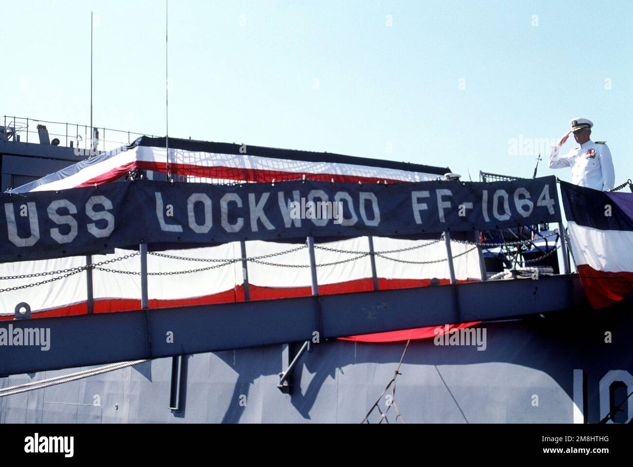 An officer aboard the frigate USS LOCKWOOD (FF-1064) salutes prior to ...