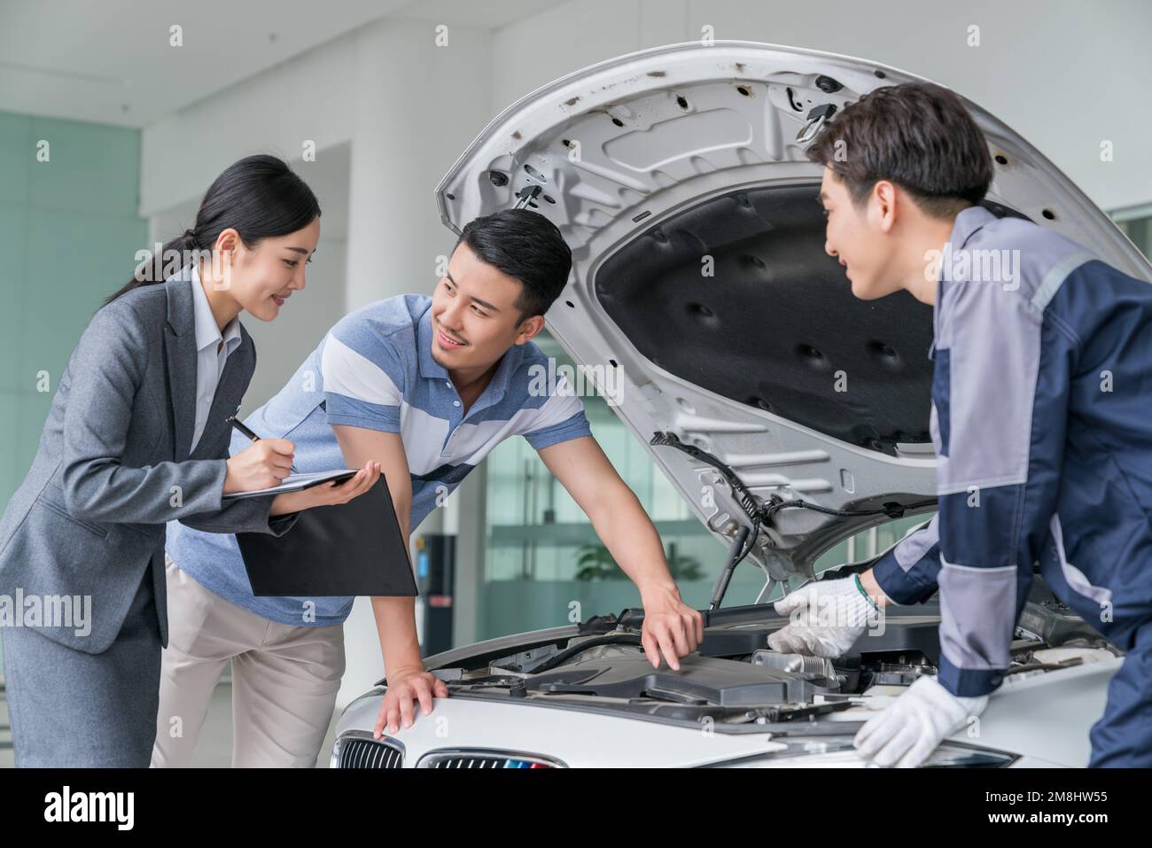 Repair shop mechanics of personnel with the customer Stock Photo - Alamy