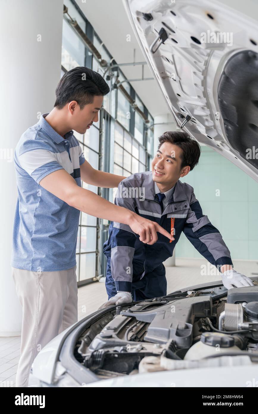 Repair shop mechanics of personnel with the customer Stock Photo - Alamy
