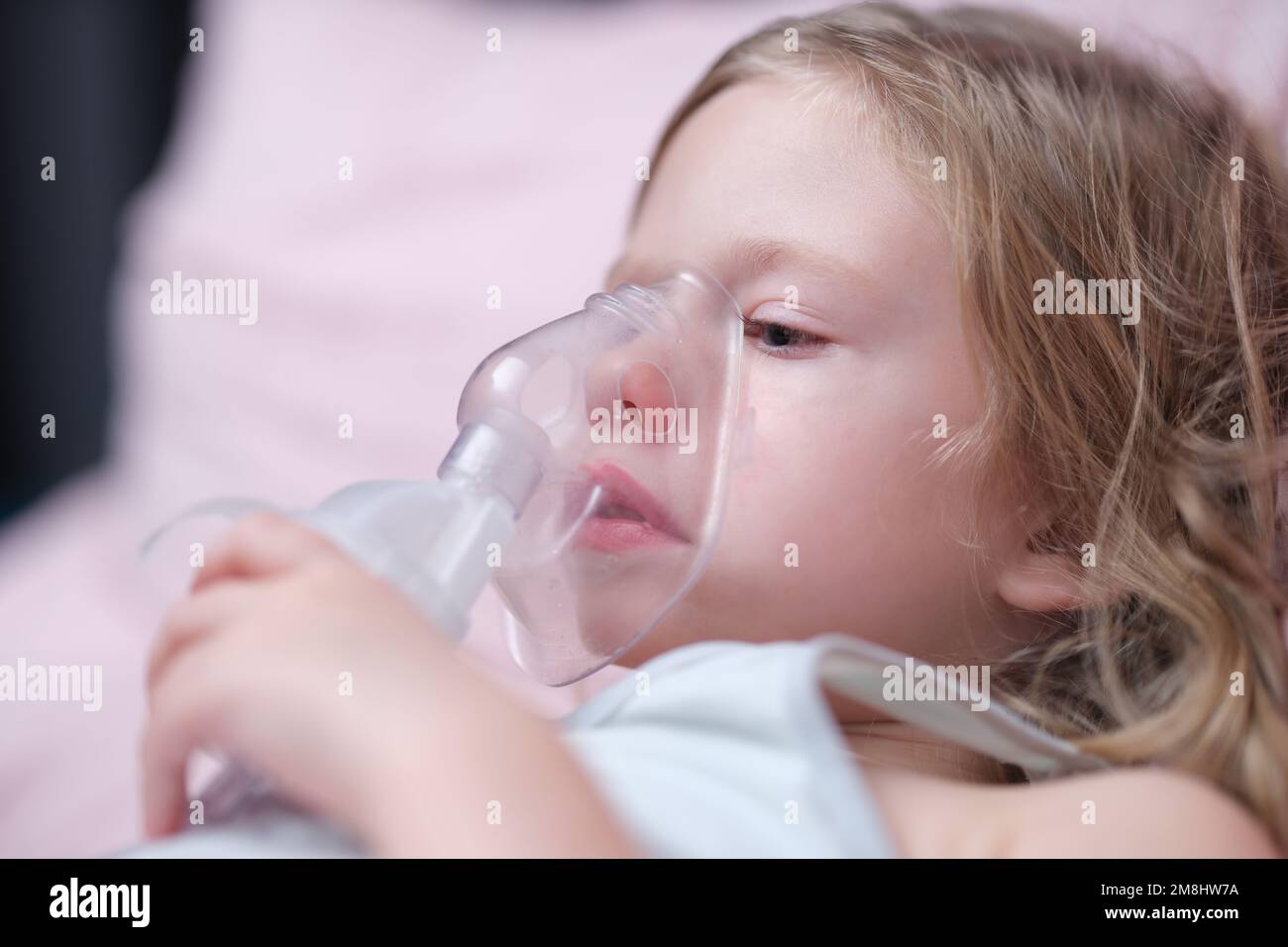 Oxygen mask of cute little girl on face on bed in hospital Stock Photo ...