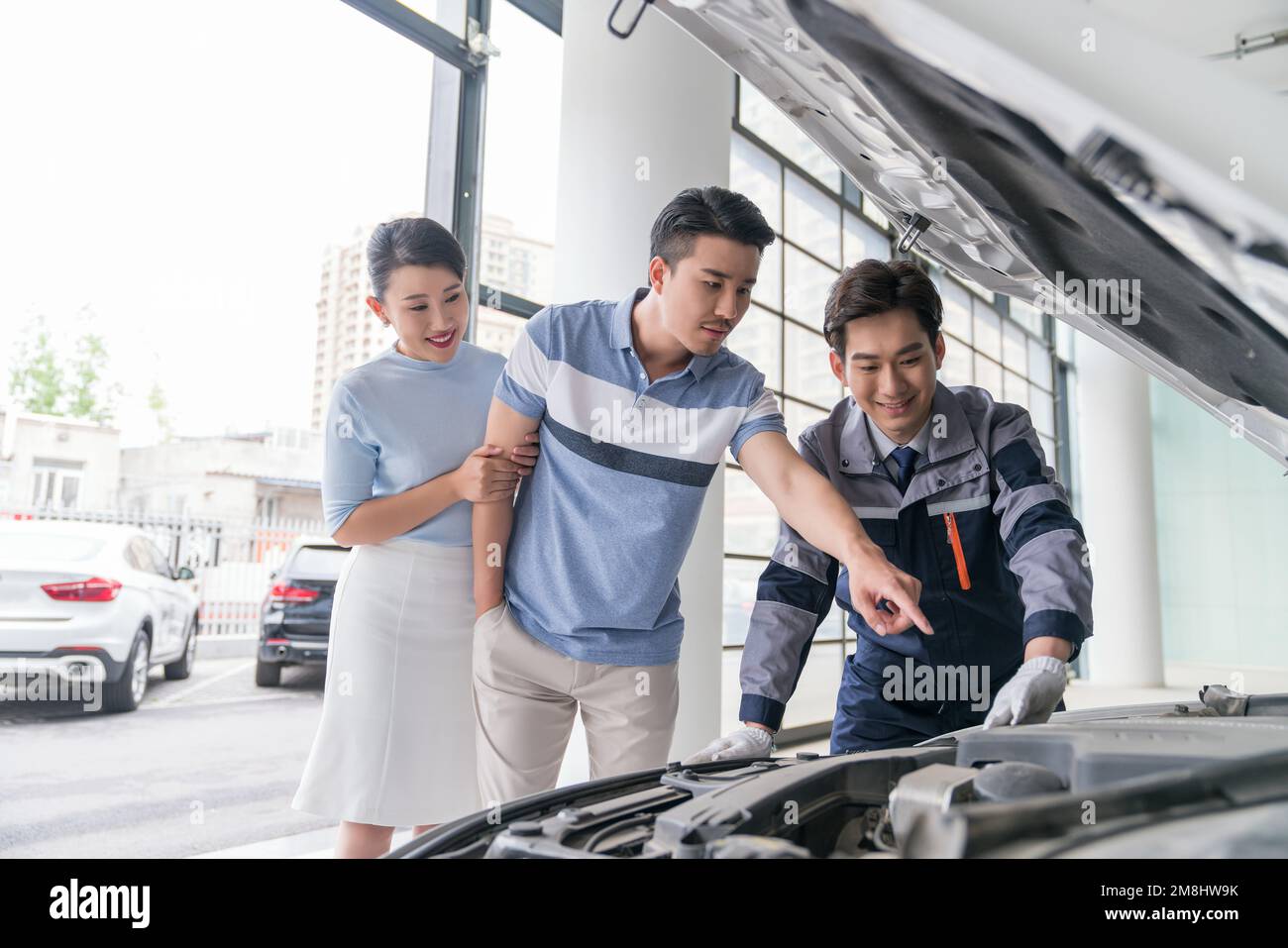 Repair shop mechanics of personnel with the customer Stock Photo - Alamy