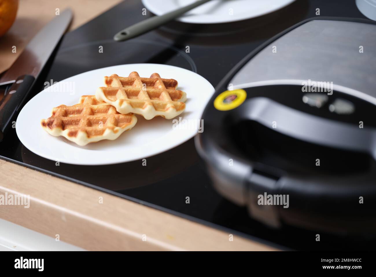 Delicious fresh sweet cooking waffles on plate in kitchen Stock Photo ...