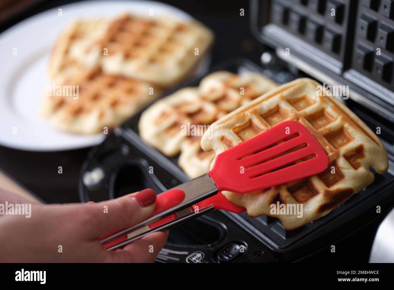 Belgian waffle dessert in waffle iron closeup Stock Photo - Alamy