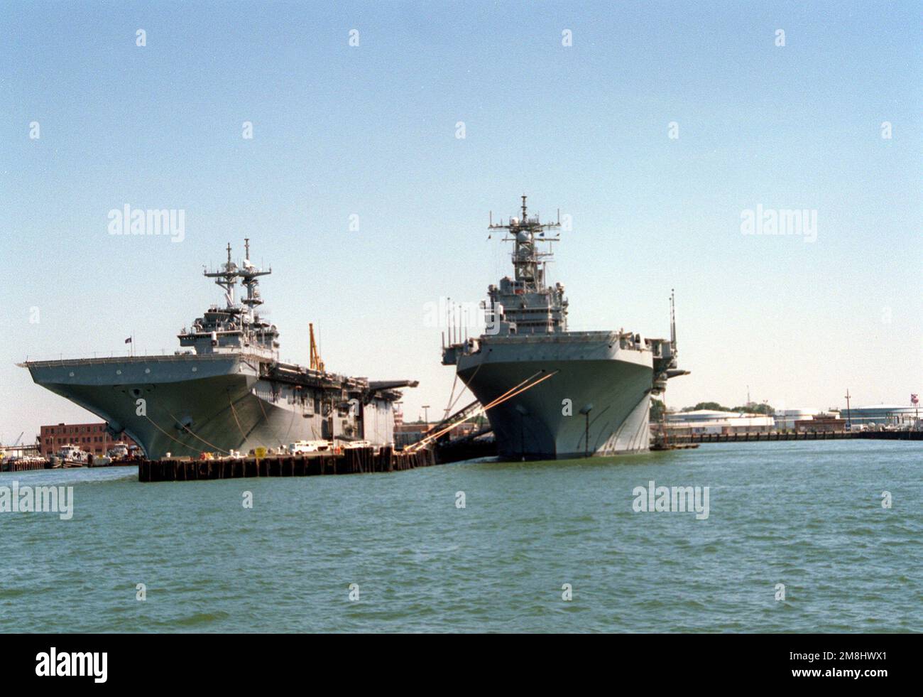 A bow view of the amphibious assault ships USS WASP (LHD-1), left, and ...