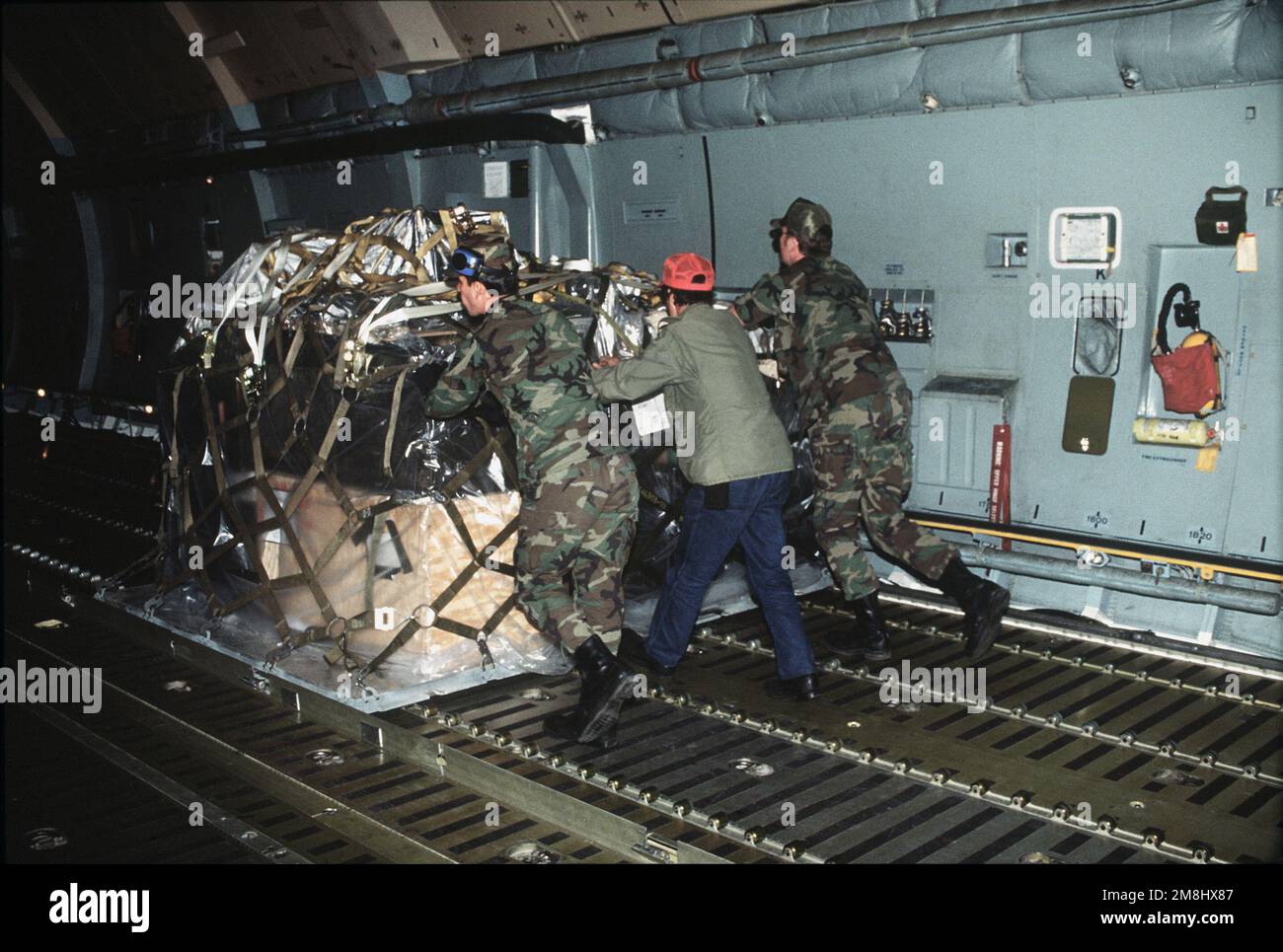 Air Force members push pallets of mobility gear into a C-5 aircraft ...