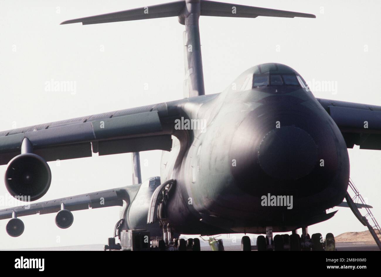 A close-up of two C-5s on the flight line, soon to be on their way to ...