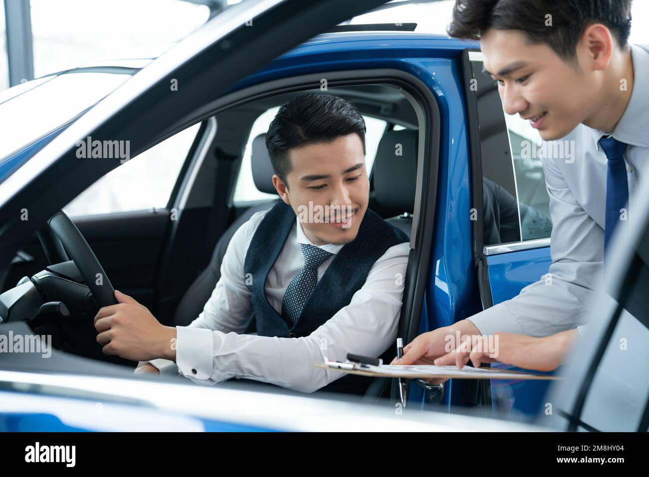 Young men to buy cars Stock Photo - Alamy