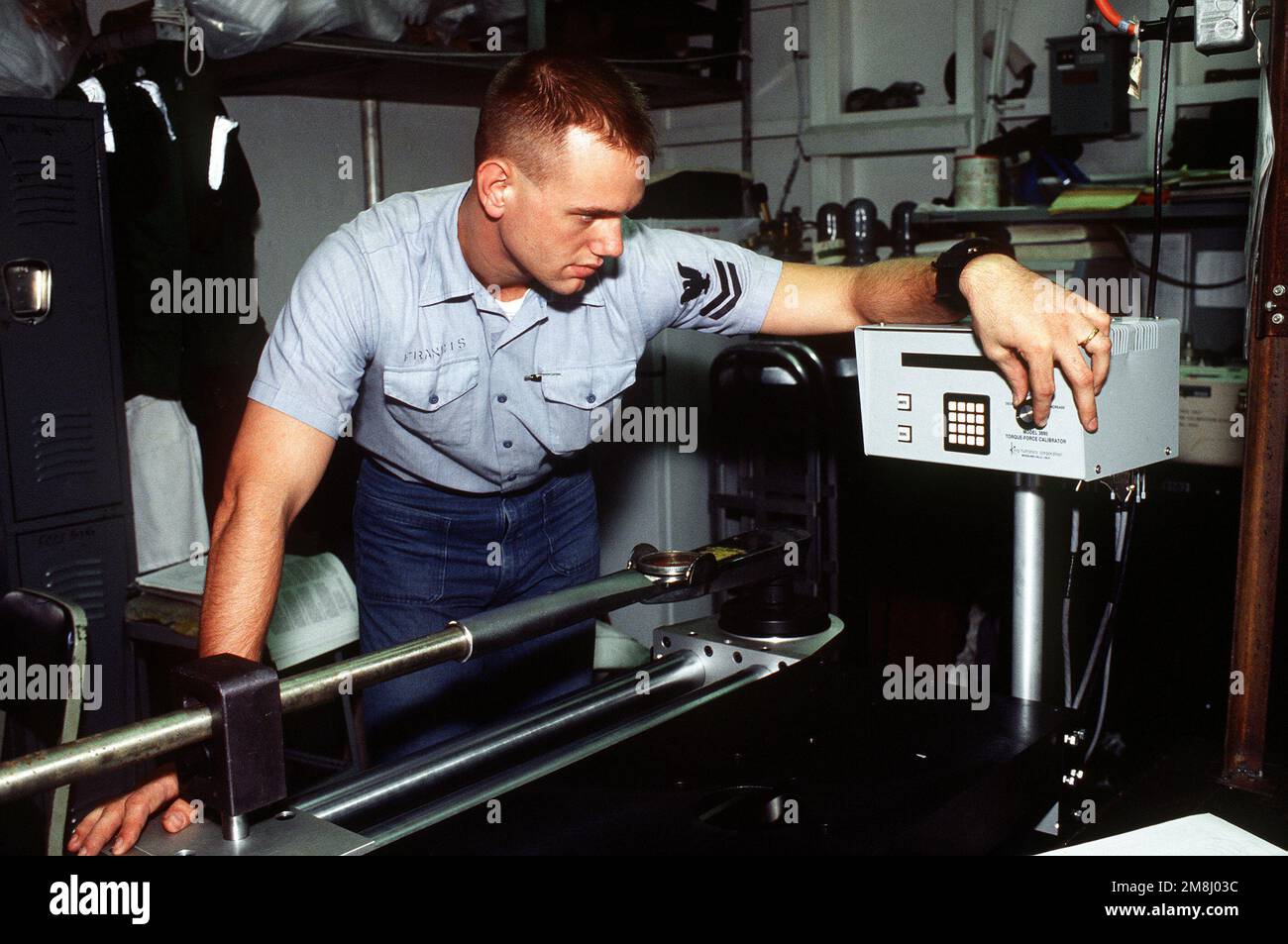 A second class machinist mate checks the torque force calibrator in the ...