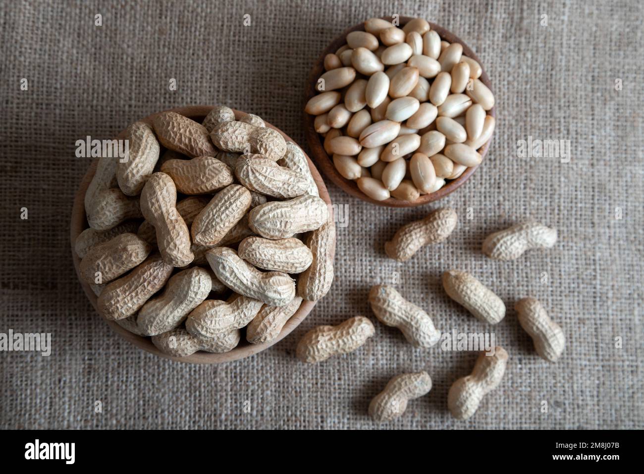 Bowl full of peeled peanuts with shelled peanuts on burlap,top view ...