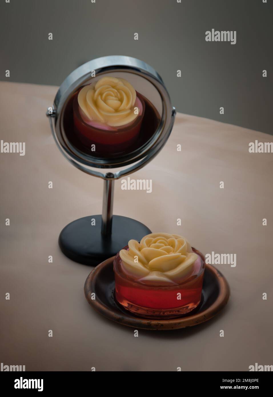 Sweet red jelly dessert layered with rose petal-shaped topping design ...