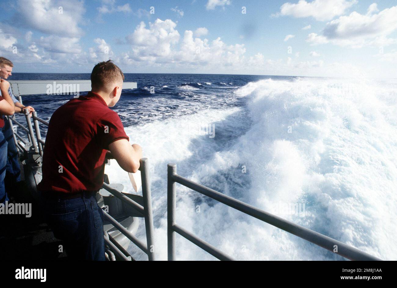 Off duty sailors on the fantail of the guided missile cruiser USS ...