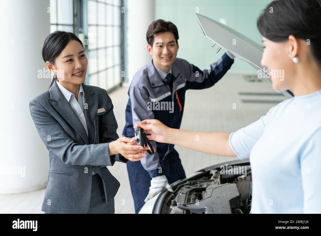 Repair shop mechanics of personnel with the customer Stock Photo - Alamy