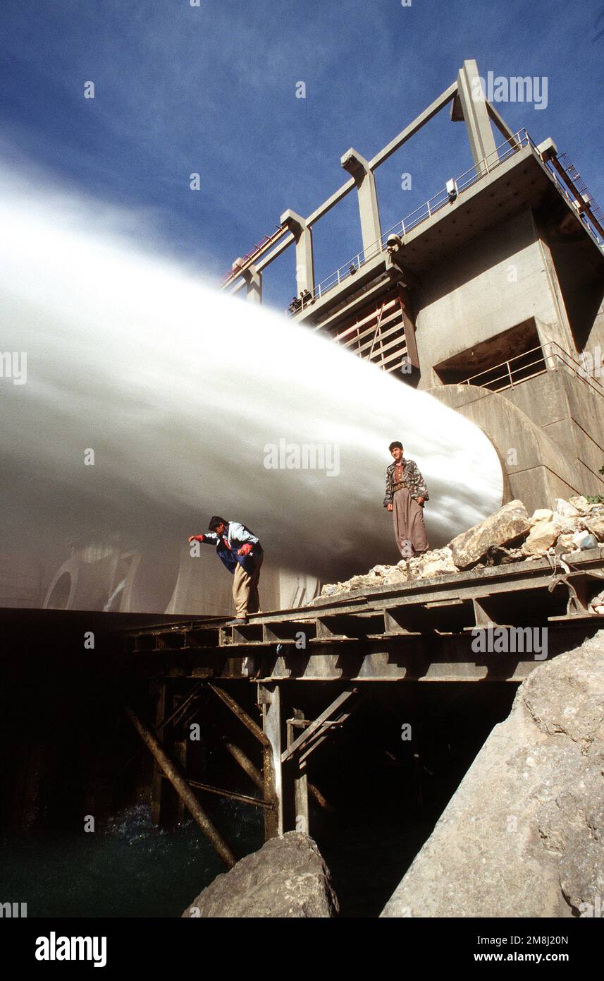 Two young men stand under Drabmdikhlan Dam's only functioning water ...