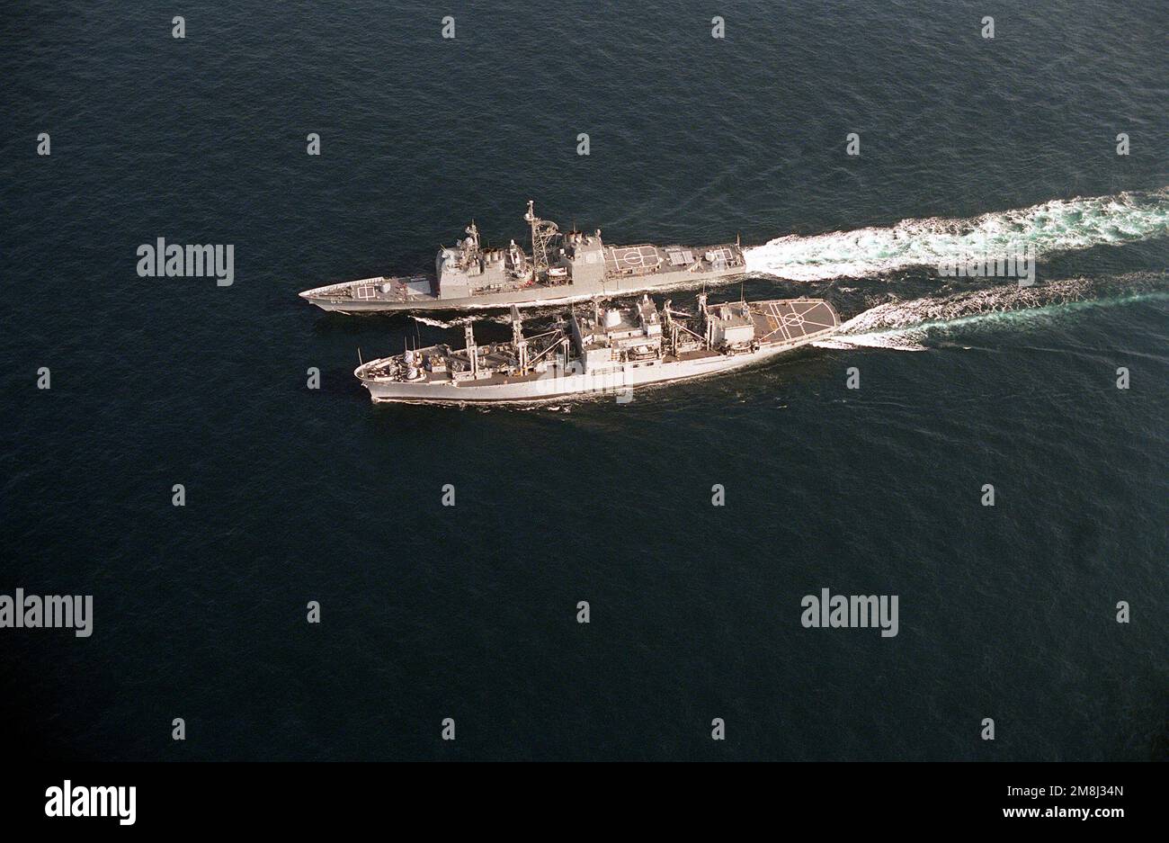 An aerial port side view of the Ticonderoga class guided missile ...