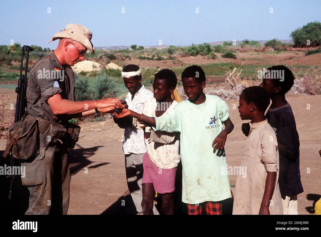A German soldier hands out candy to Somali children in Belet Weyne. The ...