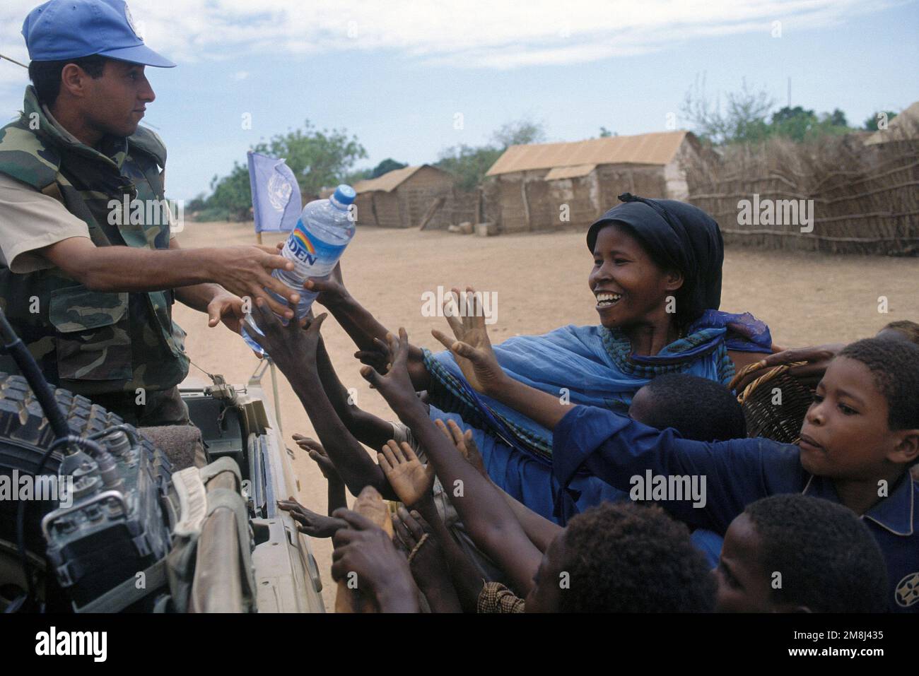 A Moroccan soldier hands out bottles of drinking water to Somalis at ...