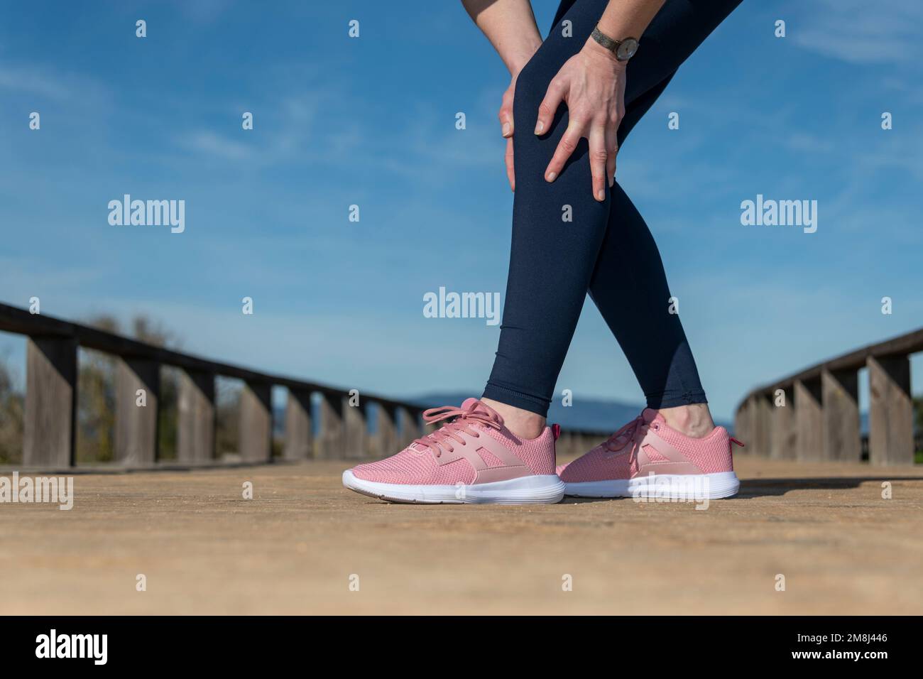 Close up of a sporty woman clutching her knee, sports injury concept ...