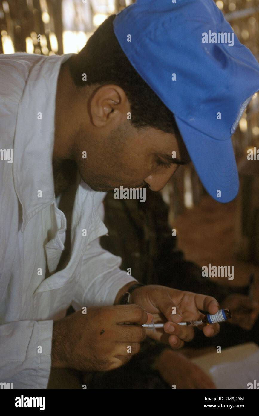 A Moroccan Army doctor prepares to administer a vaccination to a Somali ...