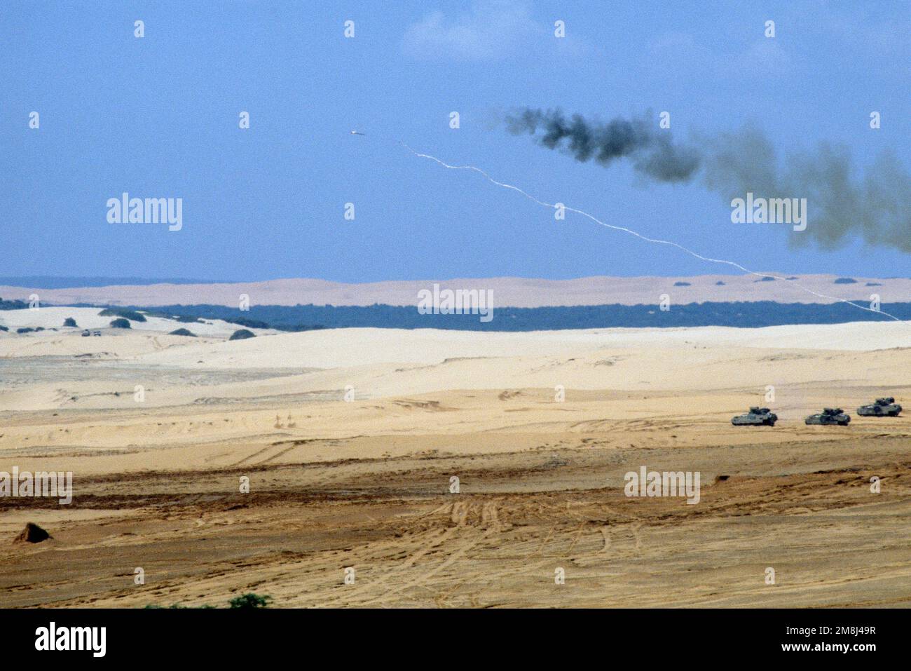 A trail of smoke and the white line charge mark the flight path of the ...