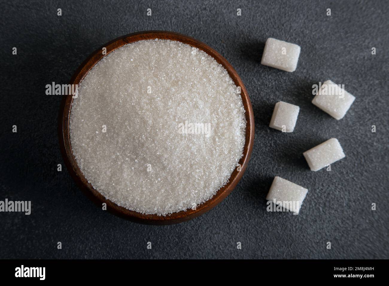 Cube sugar and granulated sugar on dark background Stock Photo - Alamy