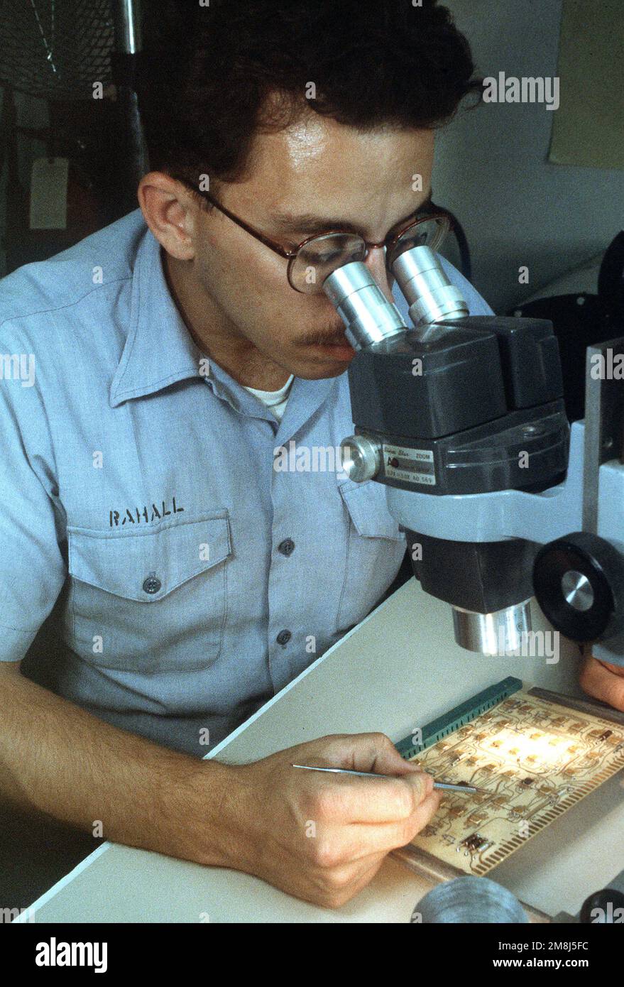 Electronics Technician First Class (ET1) Mark Rahill repairs a micro ...