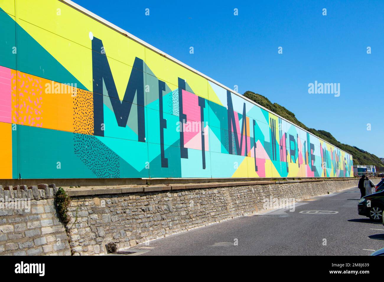 graphic wall art painting with lettering on wall near beach between ...