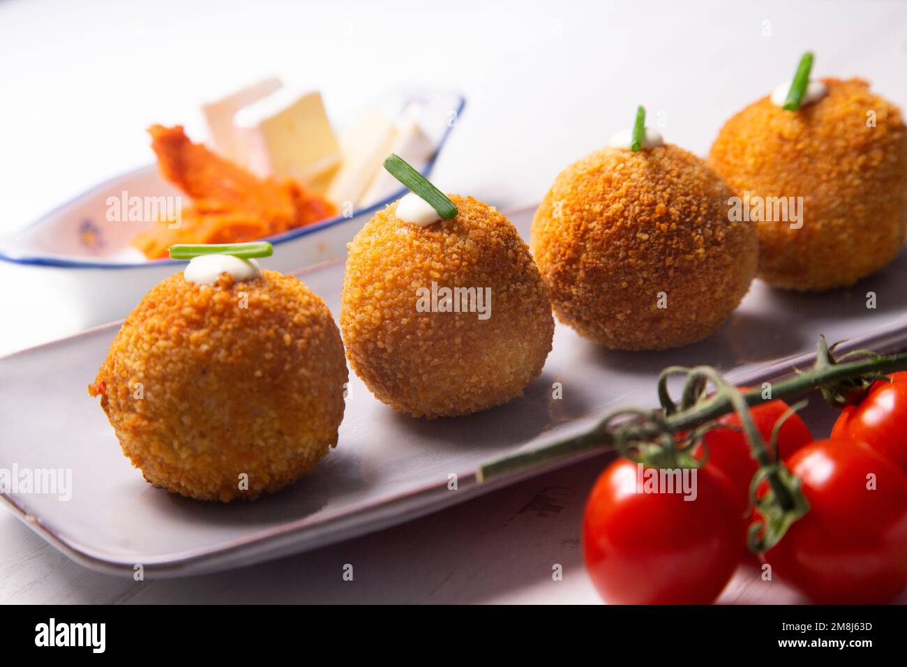 Sobrasada and brie croquettes. Portion of dough made from a dense sauce ...