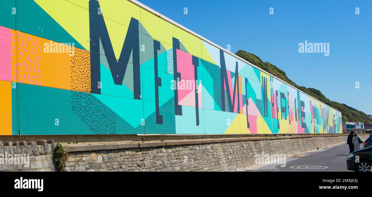 graphic wall art painting with lettering on wall near beach between ...