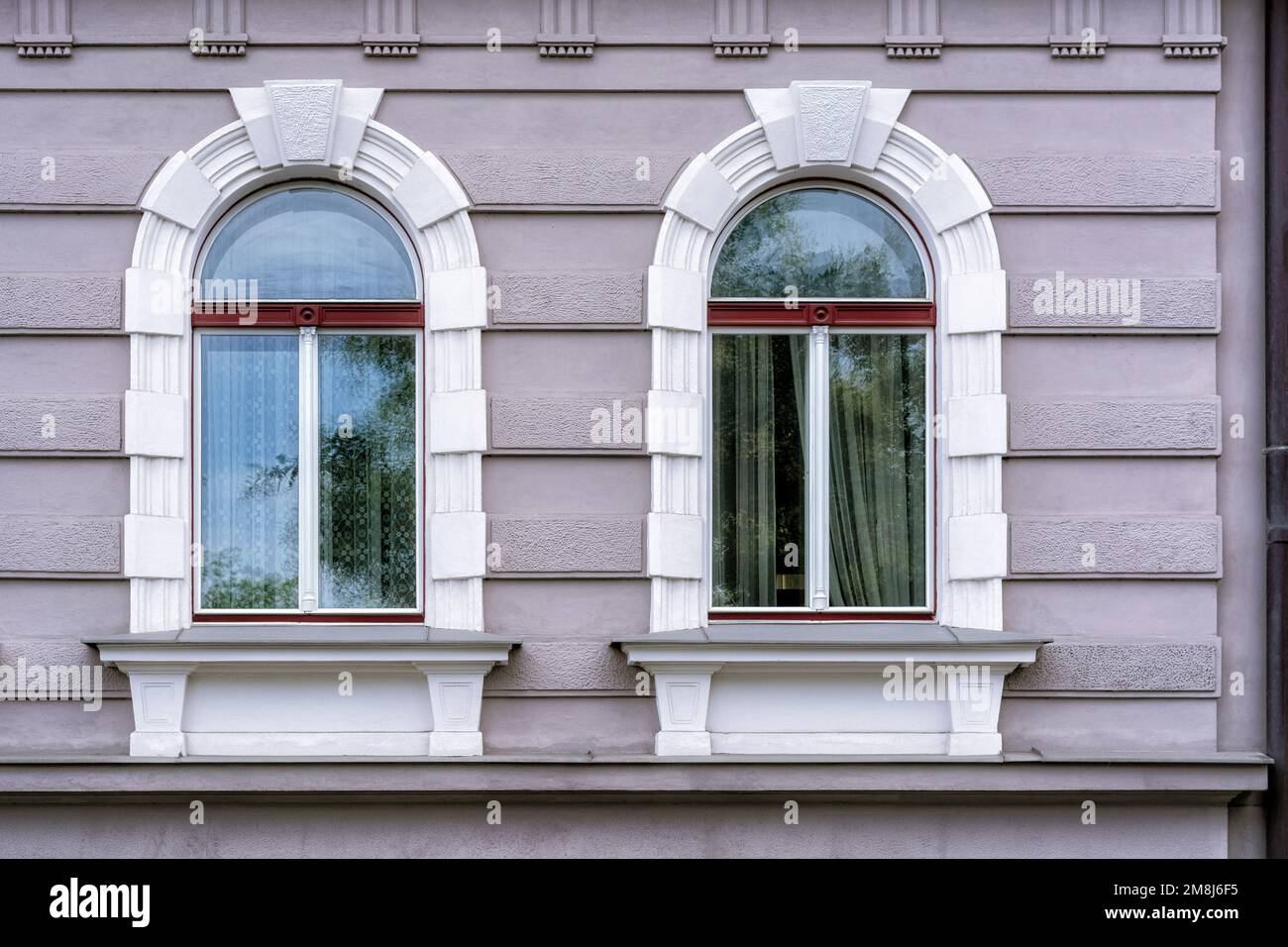 Two arched windows in a white frame against a gray wall. From the ...