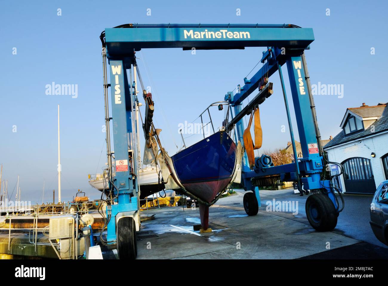 Sailing boat being hoisted from the water at Mylor Yacht Harbour ...