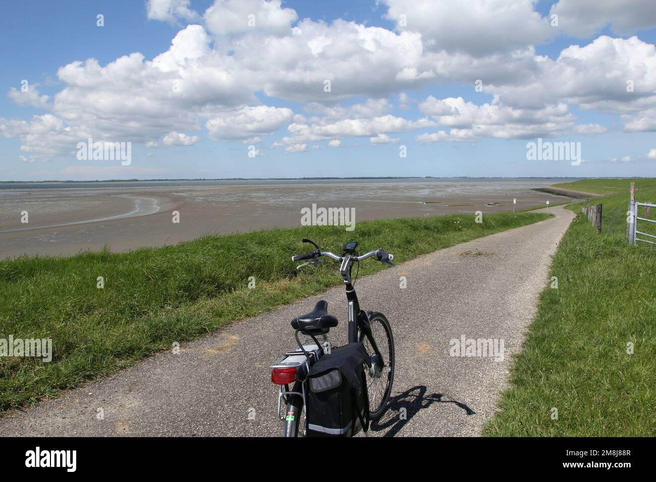 a dutch coast landscape with a tidal sand beach and a bicycle at the ...