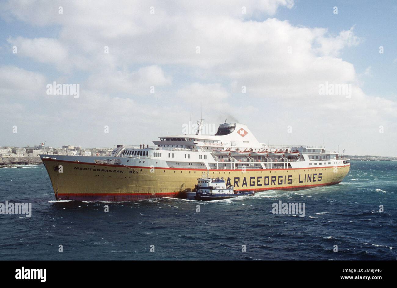 A commercial tugboat guides the Military Sealift Command chartered ...