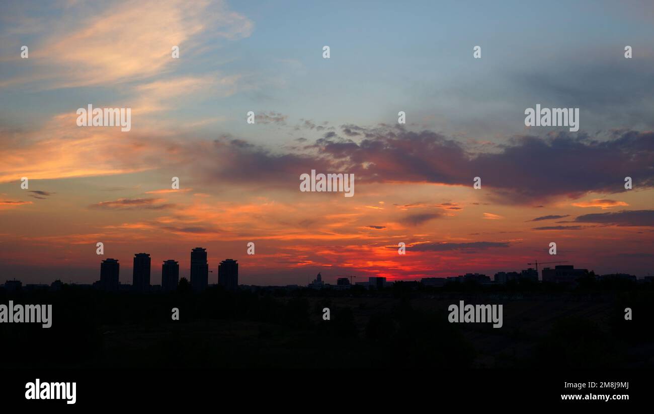 Sunset sky above city buildings silhouettes seen over Vacaresti Delta ...