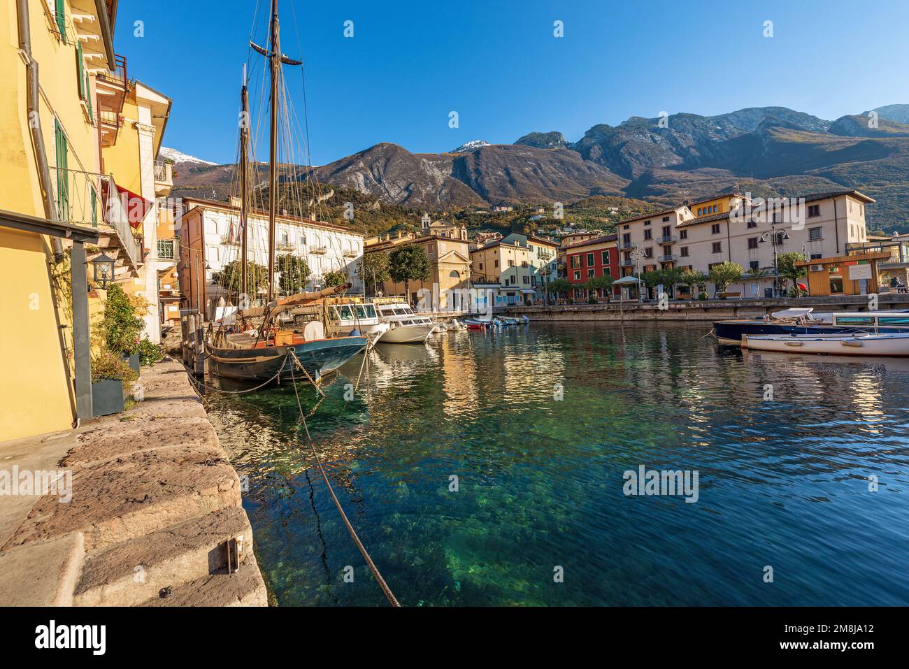 Port of Malcesine village with small boats moored. Famous tourist ...
