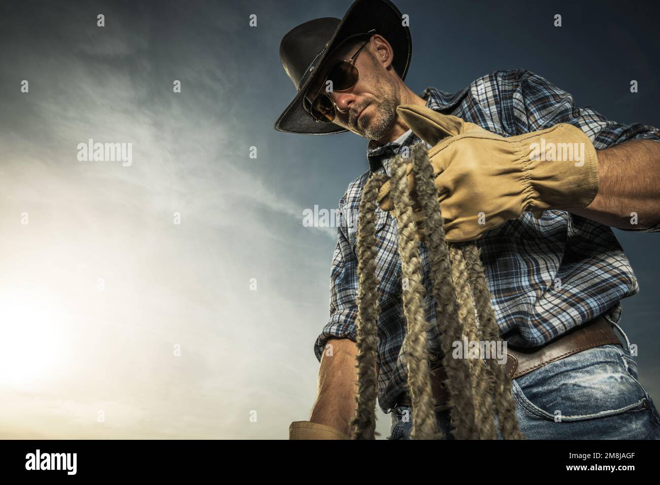 Caucasian American Cowboy Farmer with a Rope in His Hands. Farmland ...