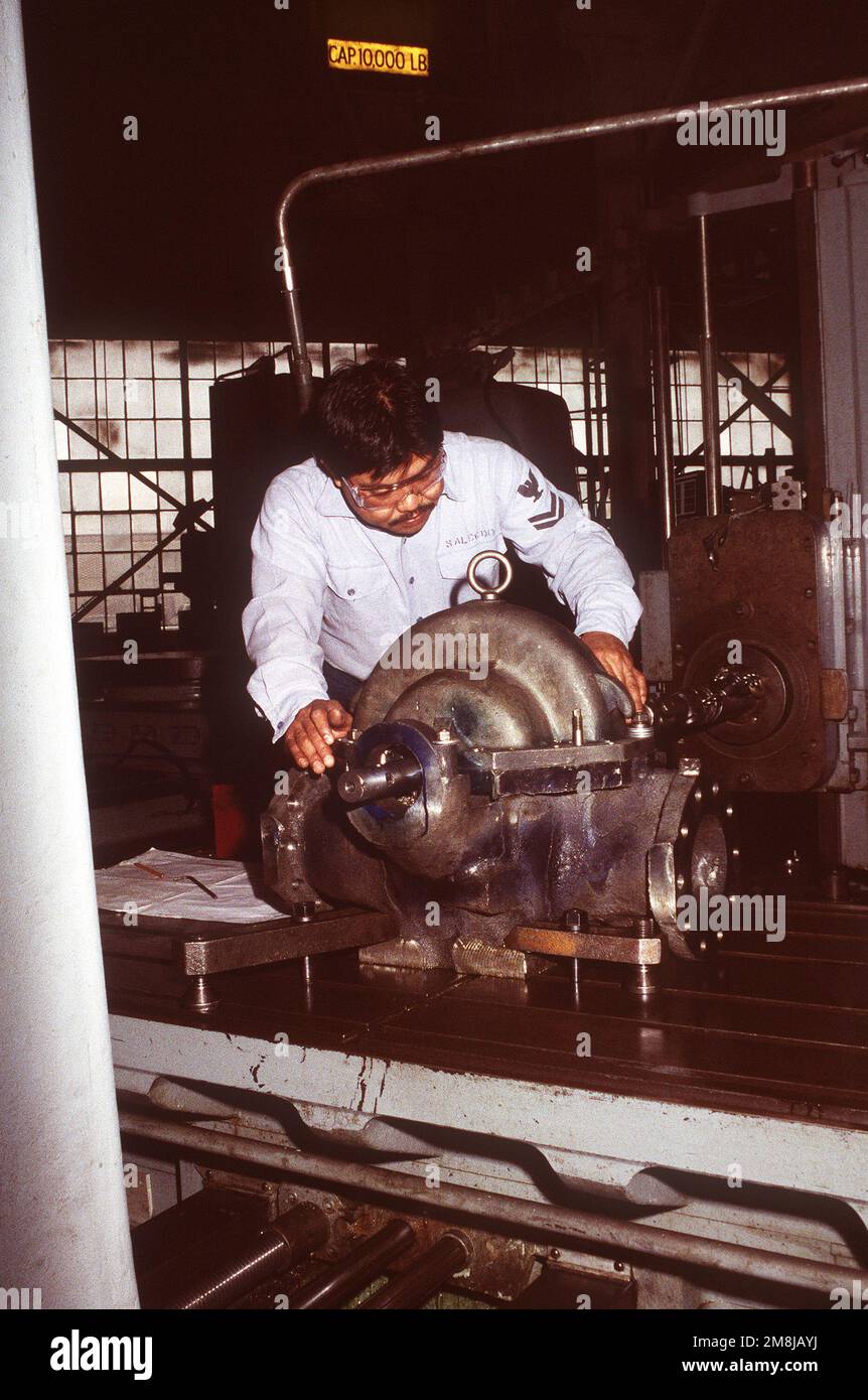 Machine Repairman Second Class (MR2) Danny Salcedo carefully checks a ...