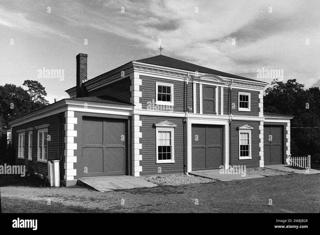 A restored vintage carriage house against a dramatic sky at the Codman ...