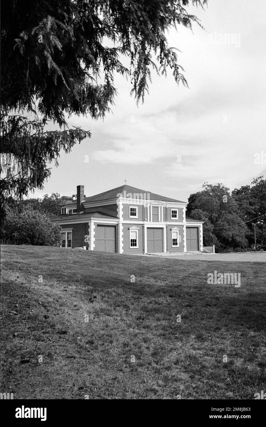 A restored vintage carriage house against a dramatic sky at the Codman ...