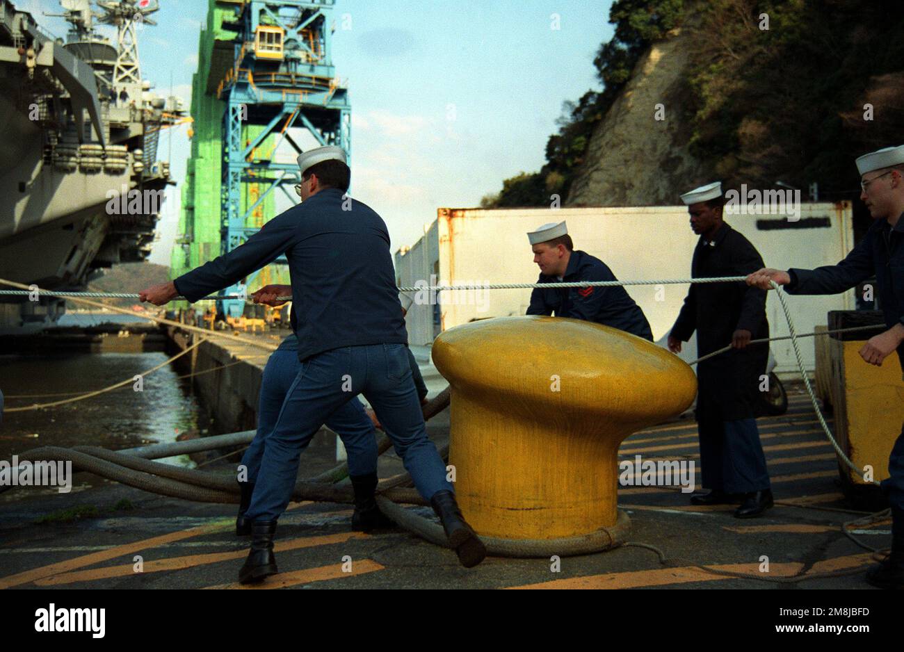 Members of the base force are shown hauling in mooring lines from the ...