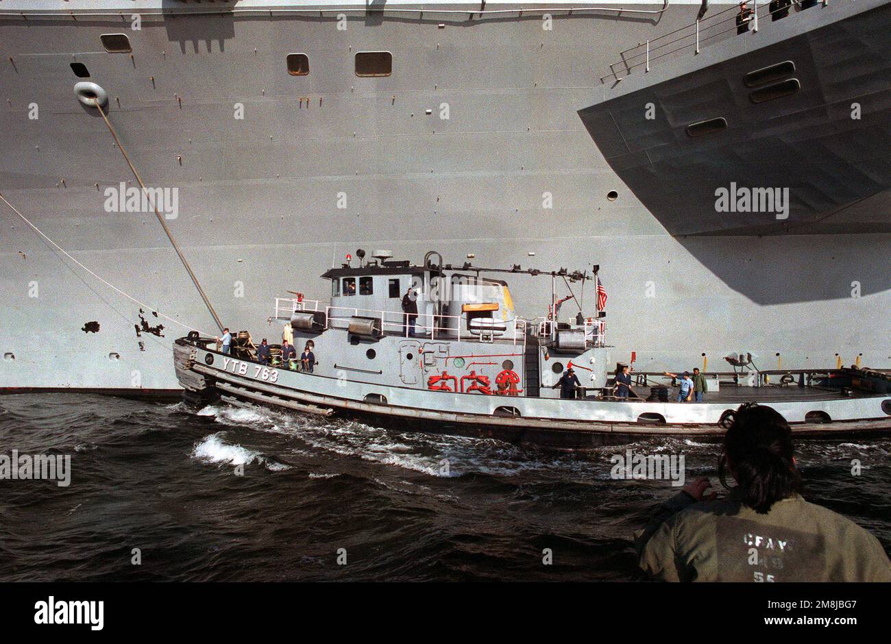 A port side view of the large harbor tug MUKEGON (YTB-763) moving in ...