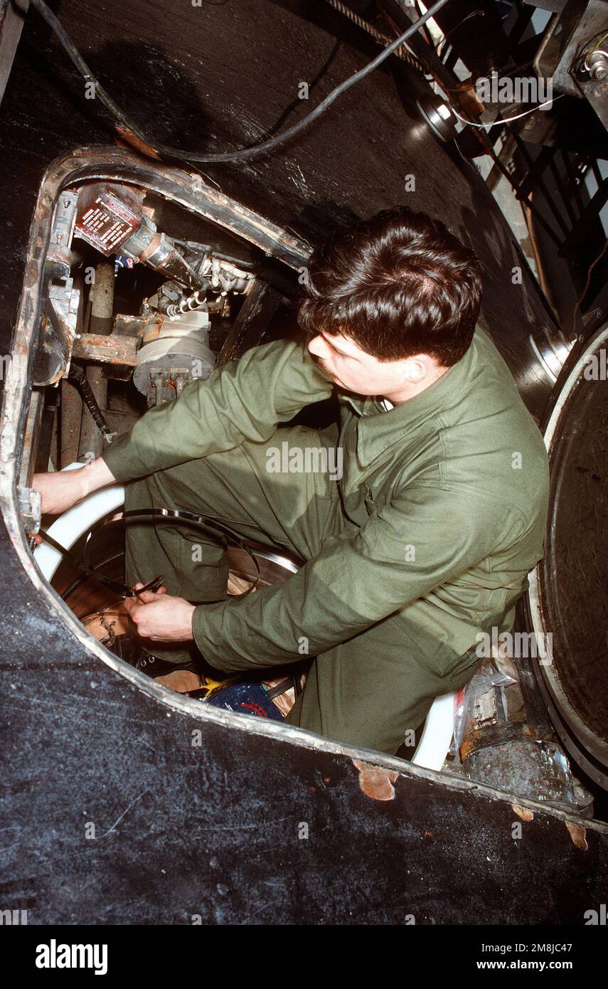 Fire Control Technician First Class (FT1) Todd Grenieo is shown banding ...
